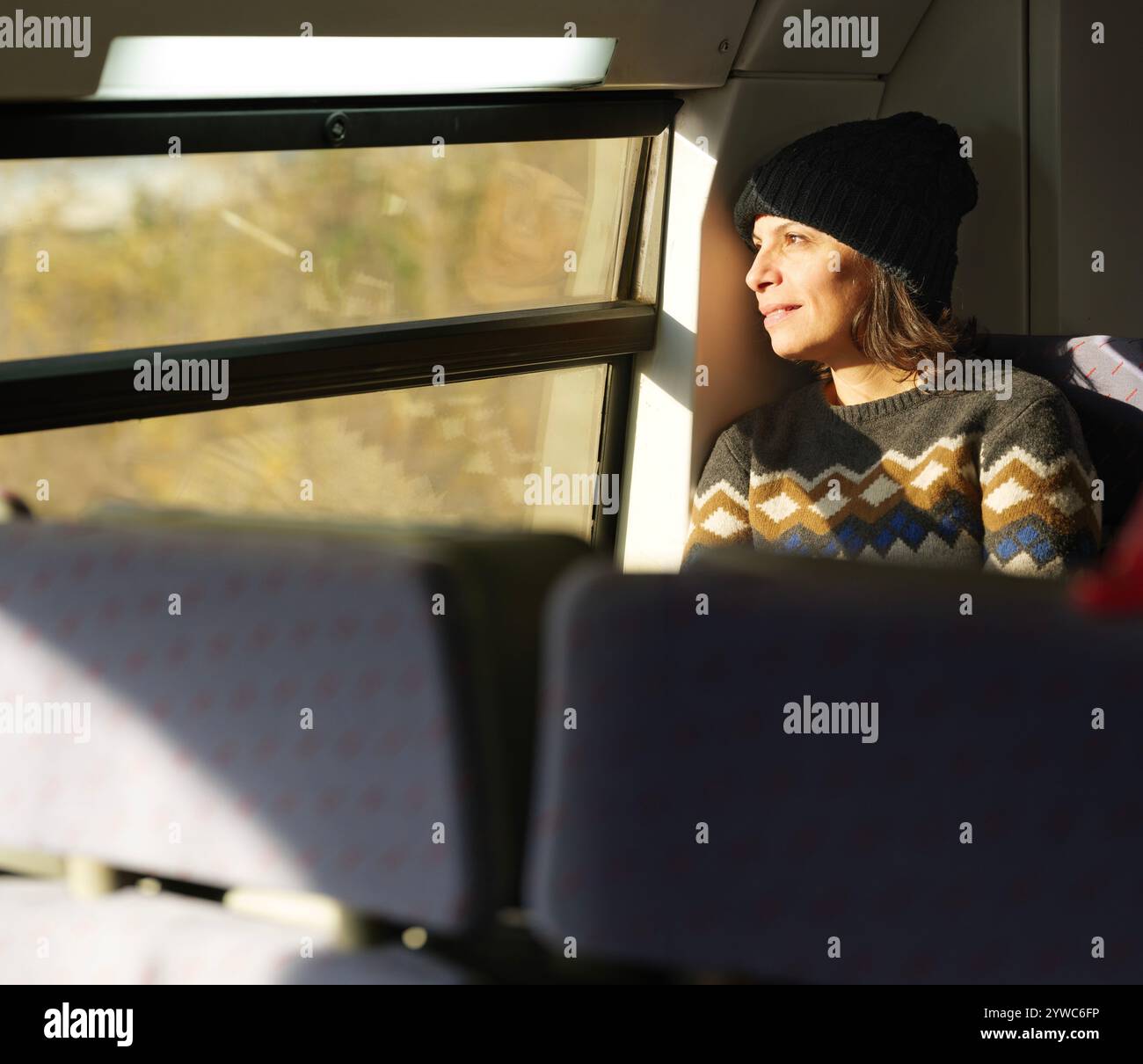 A nostalgic passenger gazing out of her train carriage window, savoring ...