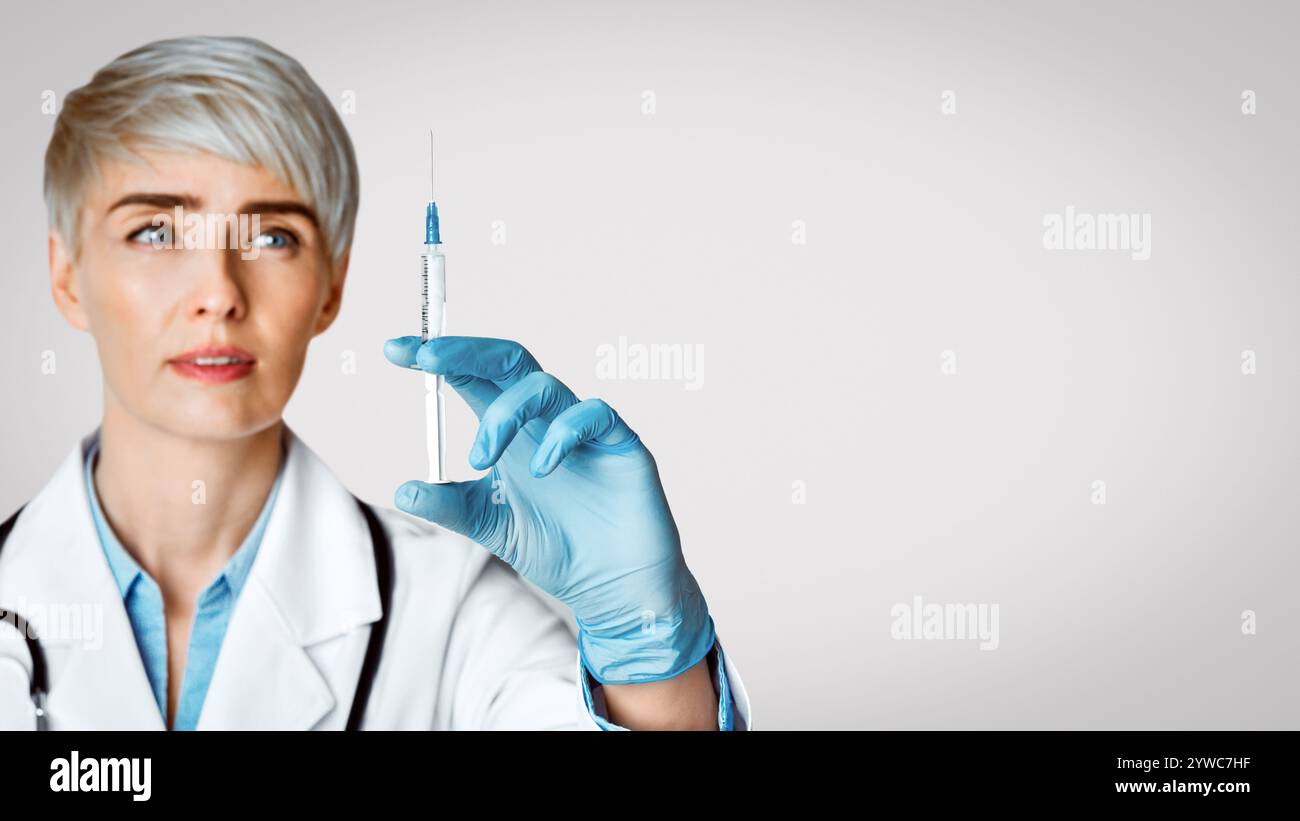 Nurse makes injection. Woman in white coat with medical gloves looks at ...