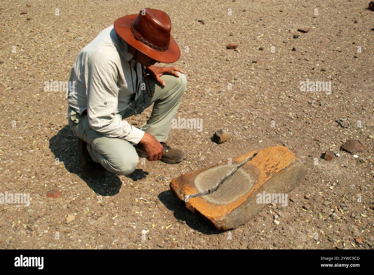 Overhead view of a Man looking at an unusual rock in the wilderness ...