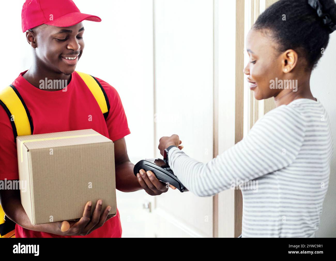 African Woman Receiving Box From Deliveryman Paying Using Smartwatch ...