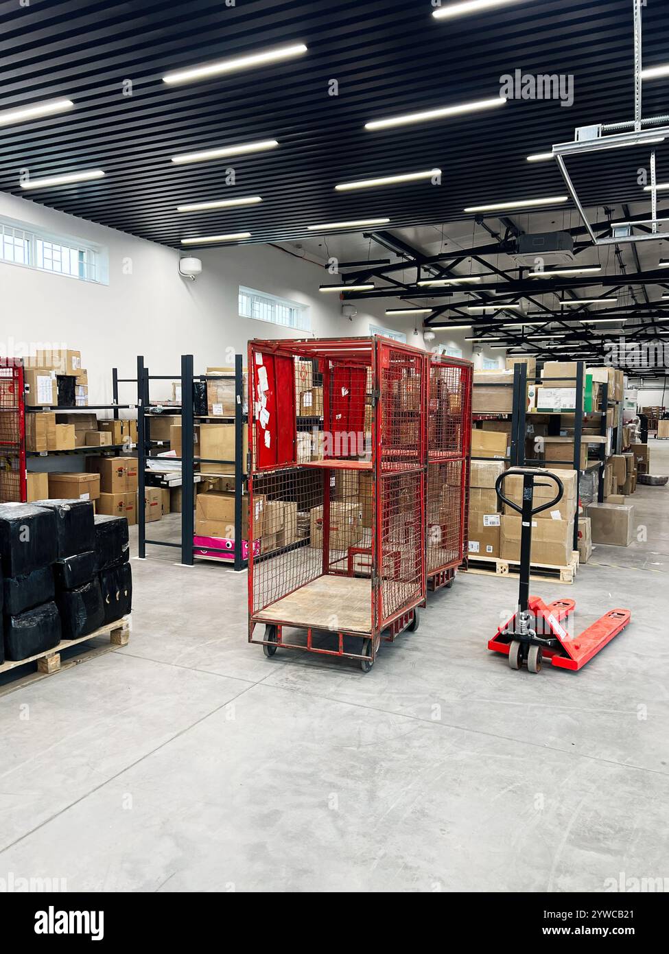 A spacious warehouse features shelving units filled with boxes and ...
