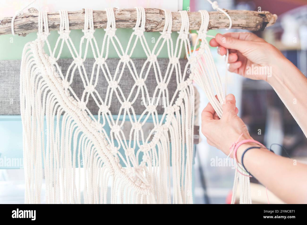 Close-up of a woman weaving a macrame craft product Stock Photo - Alamy