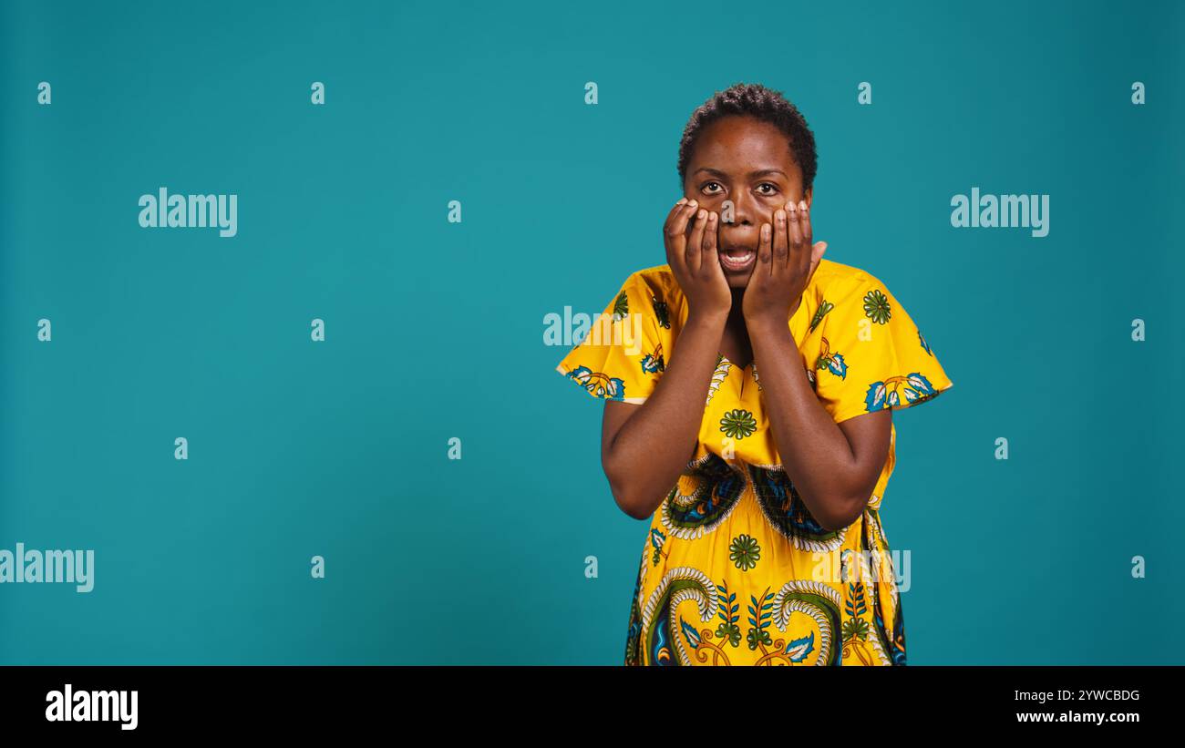 Playful cute girl sticking tongue out and fooling around in studio ...