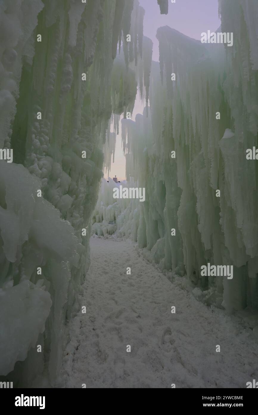 A snowy path between two walls made out of frozen ice and icicles ...