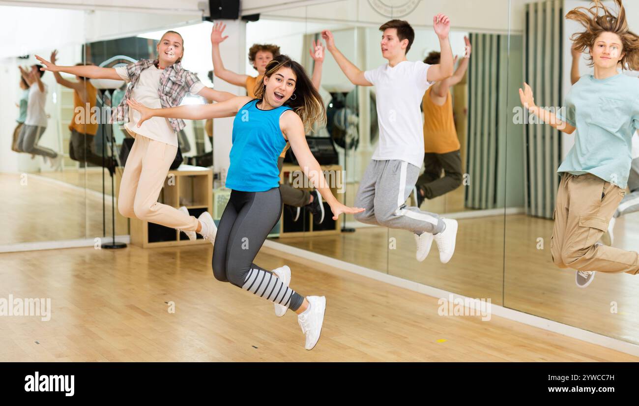 Group of cheerful sportive teenagers jumping in dance hall Stock Photo ...