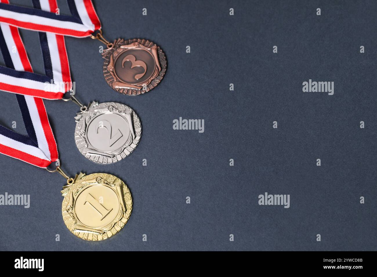 Golden, silver and bronze medals on grey background, space for text ...