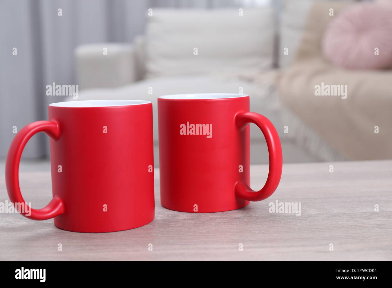 Blank red ceramic mugs on white wooden table. Mockup for design Stock ...