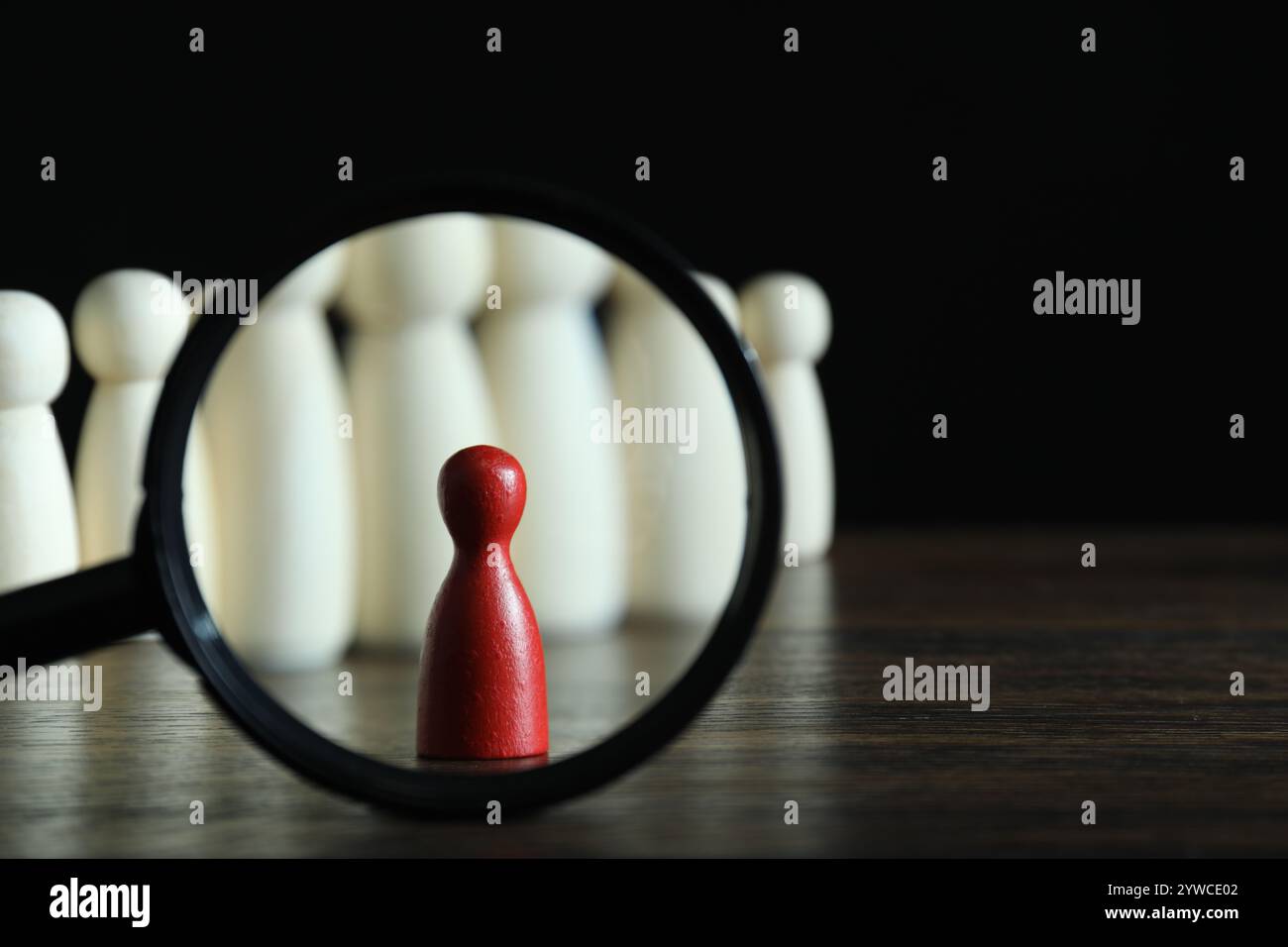 Human resources concept. Looking at red figure through magnifying glass ...