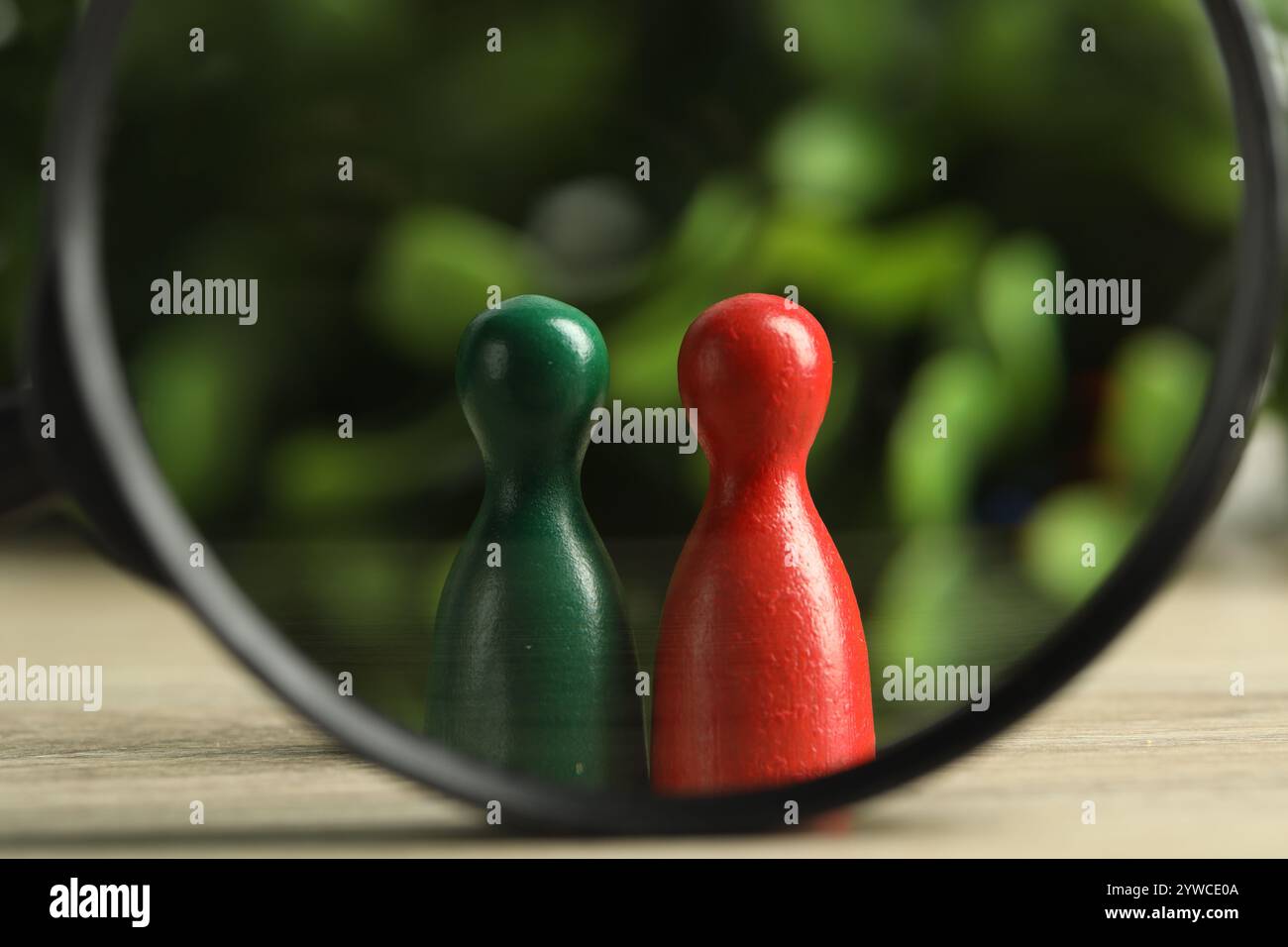 Human resources concept. Looking at color figures through magnifying ...