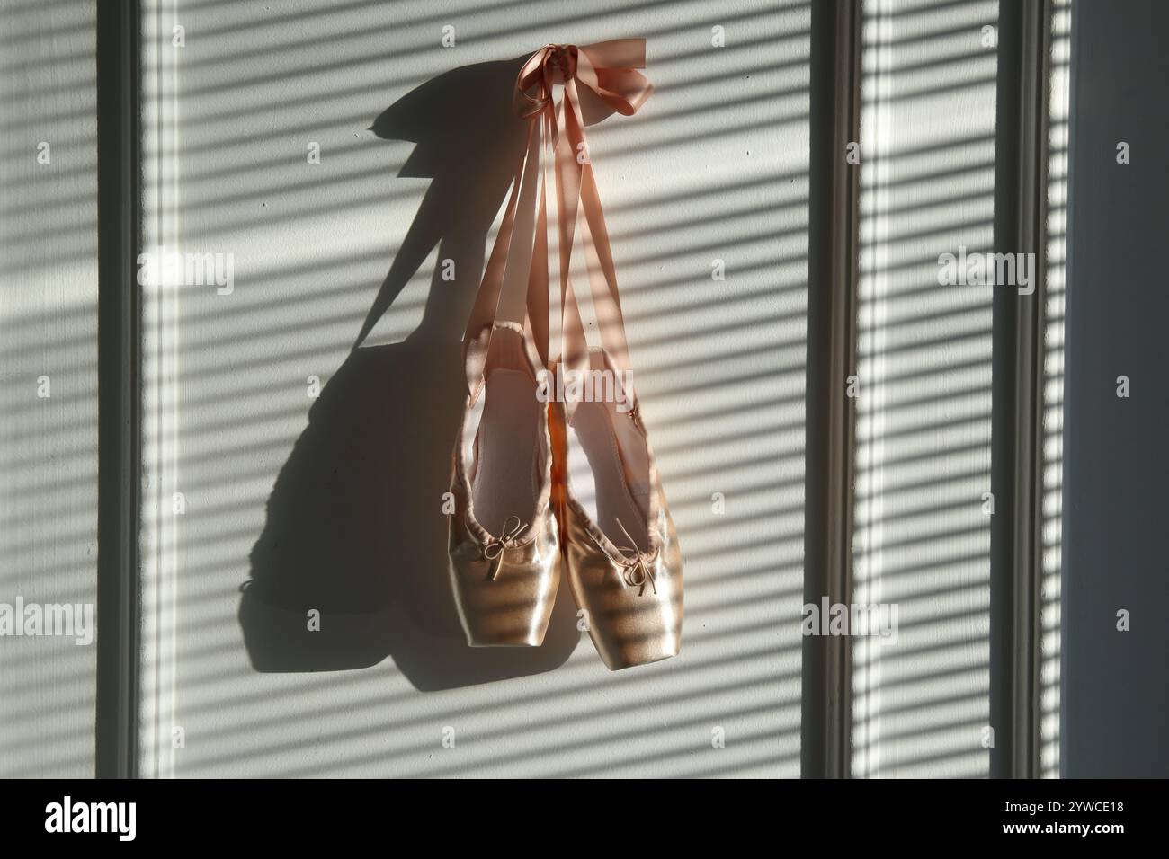 Pair of beautiful pointe shoes hanging on white wall Stock Photo - Alamy