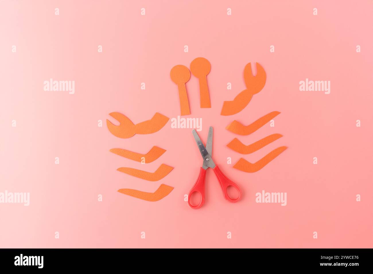 an arrangement of orange paper cutouts on a pink background, six curved ...