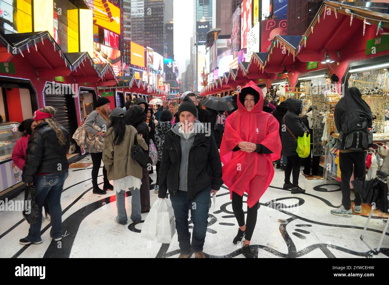 People walk through a pop-up holiday market during a rainstorm in Times ...