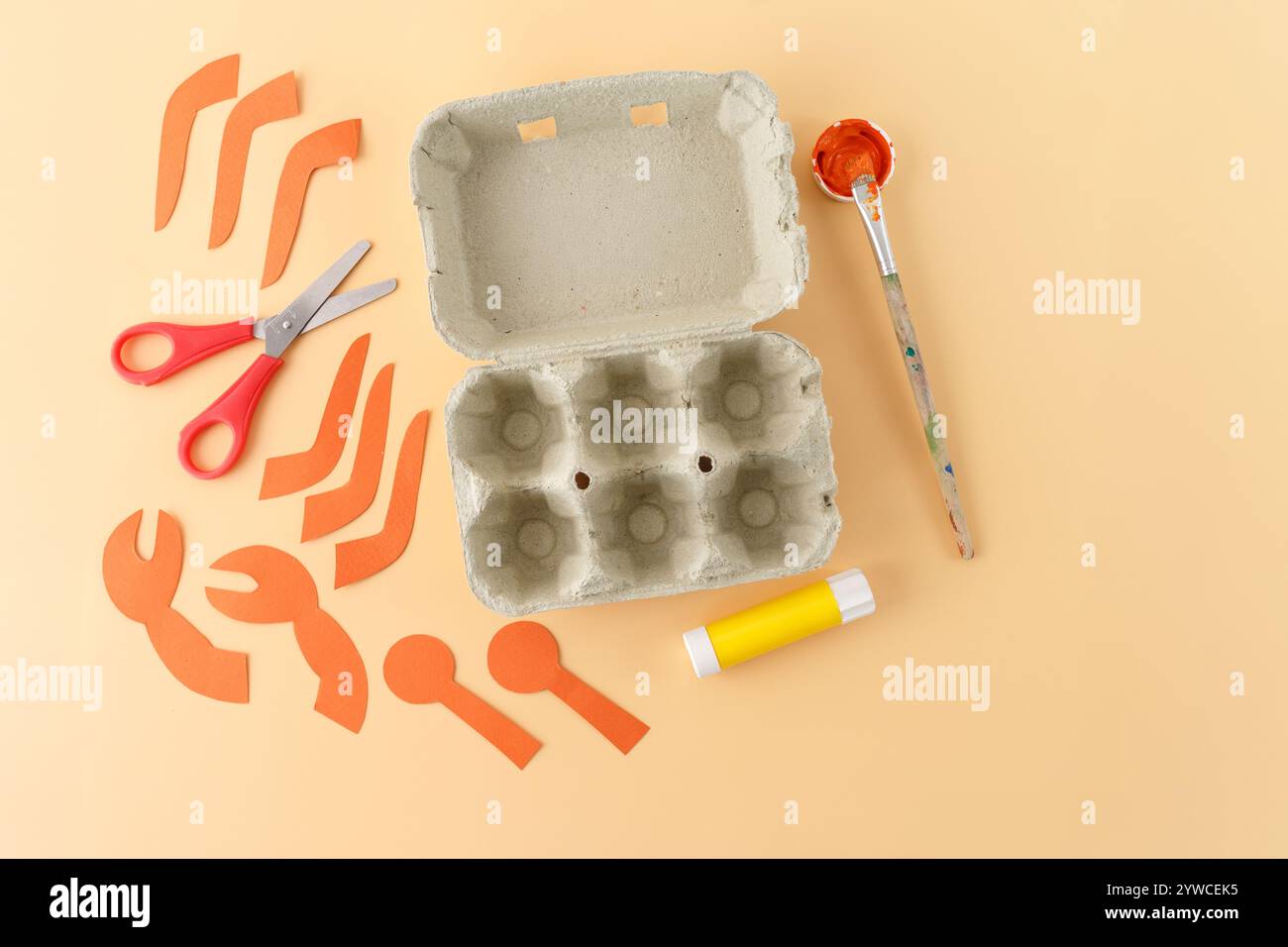 a collection of crafting materials arranged on a light orange surface ...