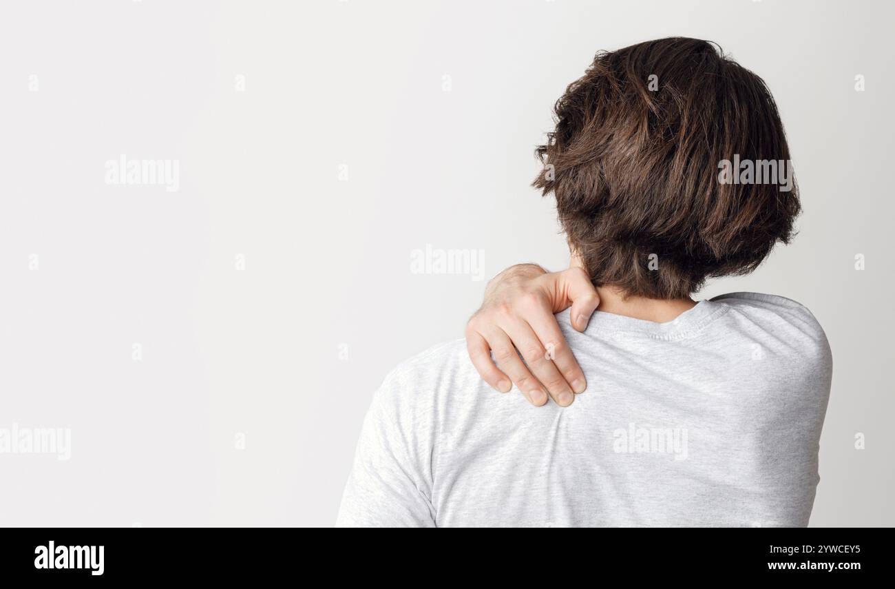 Pain in back and shoulder from working at computer. Man presses his ...