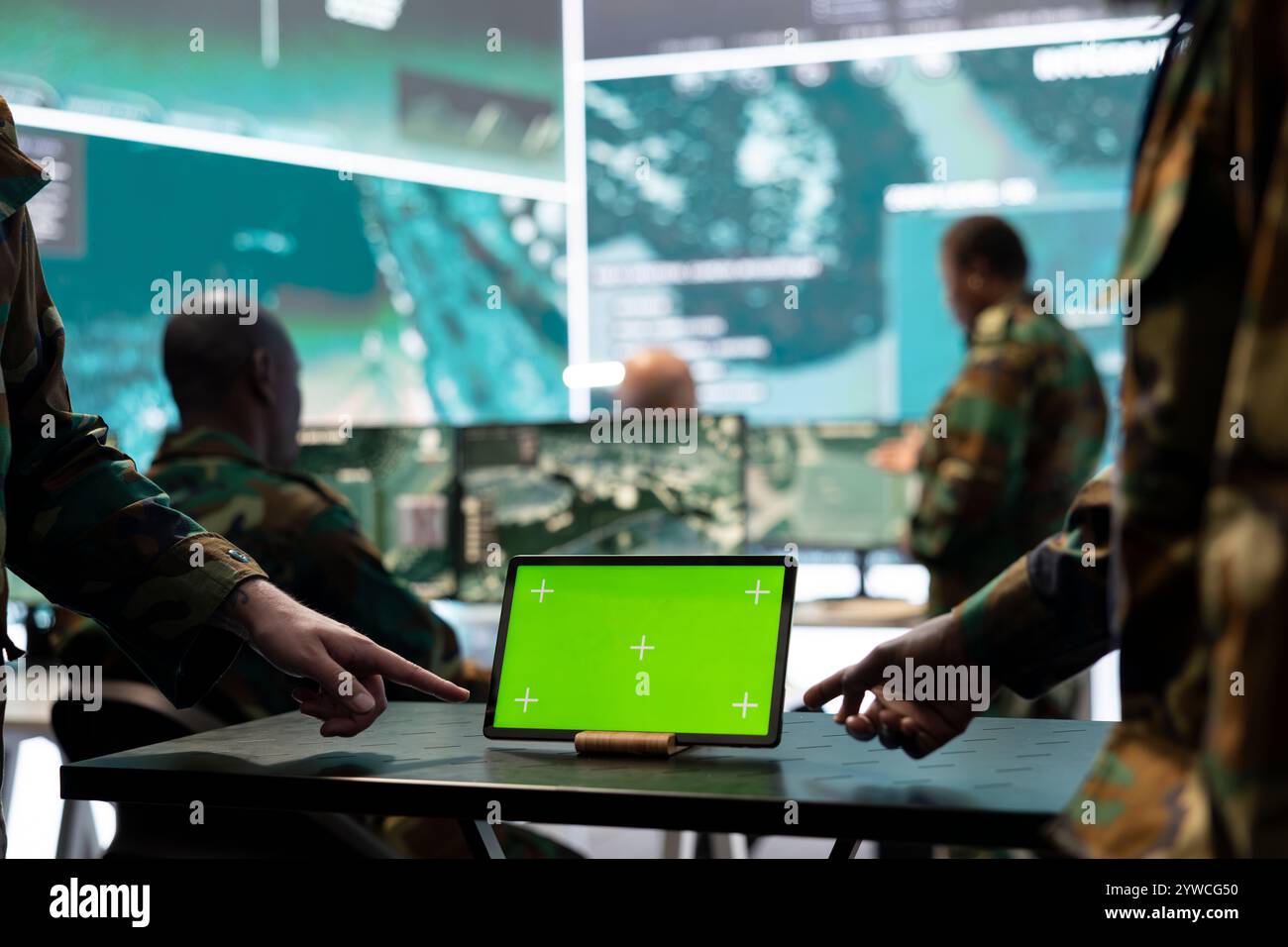 Two servicemen working in team with a green screen mockup, using a ...