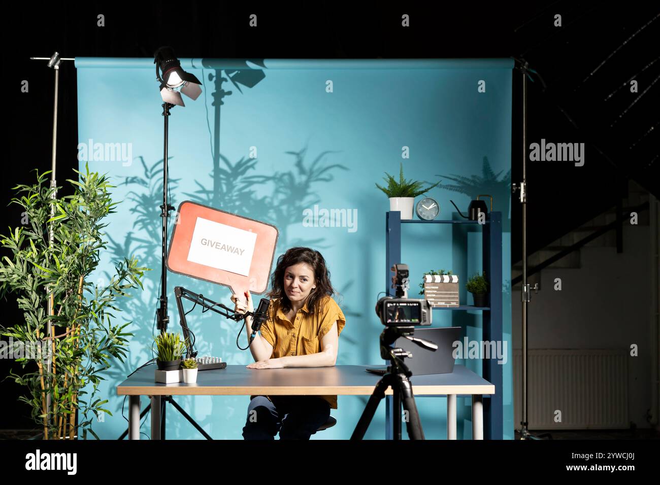 Social media content creator promoting giveaway with red cardboard sign ...