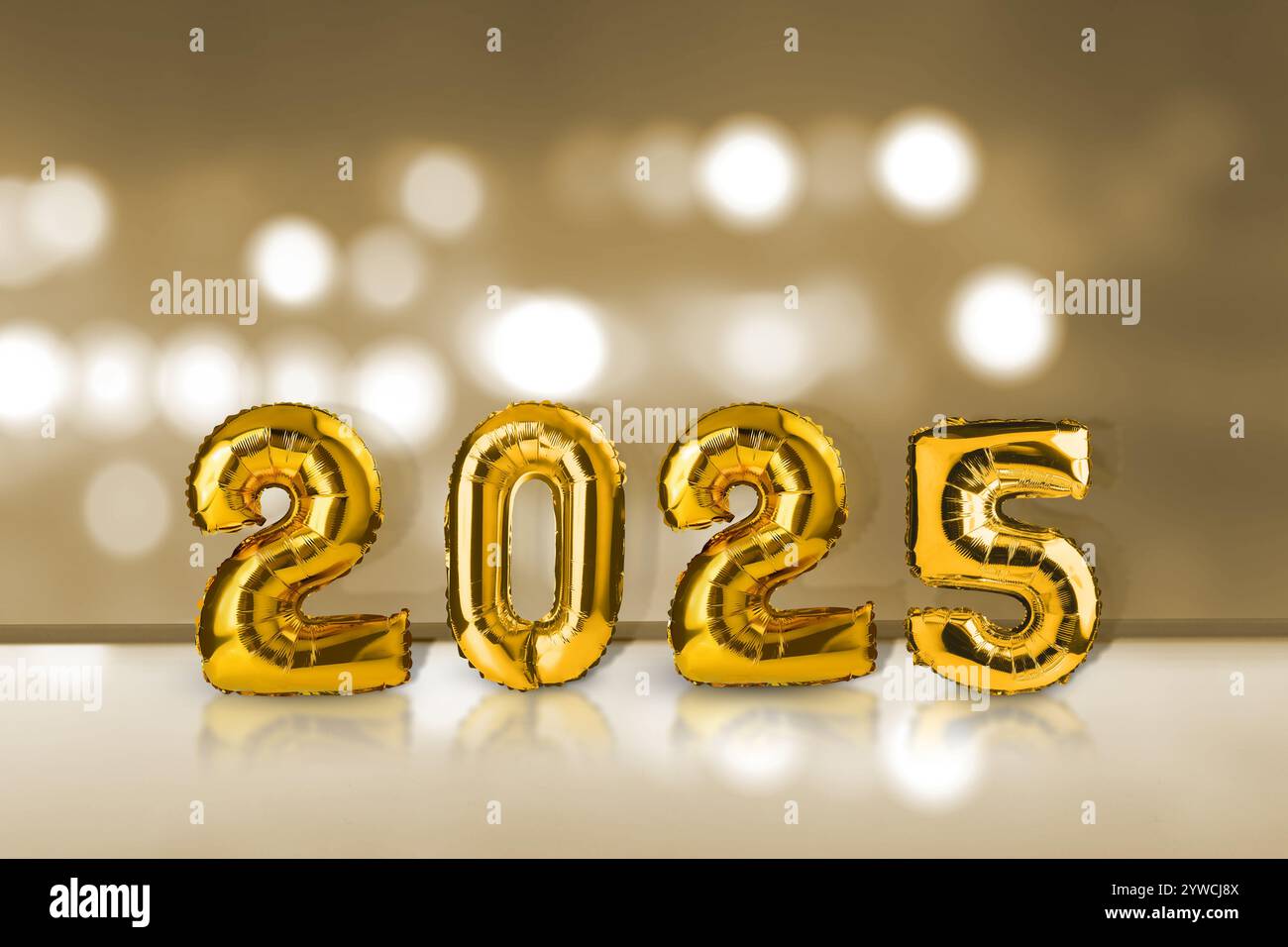 Golden helium balloons with the number 2025 on the table with abstract bokeh lights background ...
