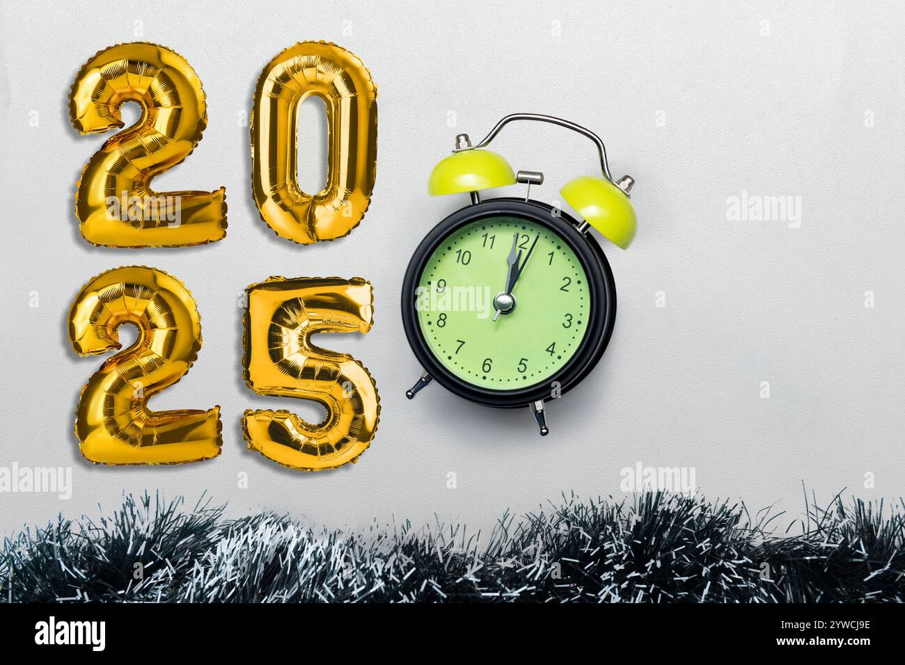 Golden helium balloons with the number 2025 and an alarm clock on a ...