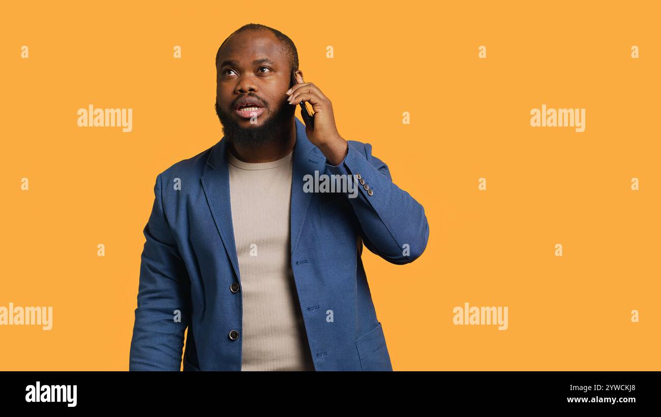 Joyous man with positive emotion, enjoying talking with friends phone ...