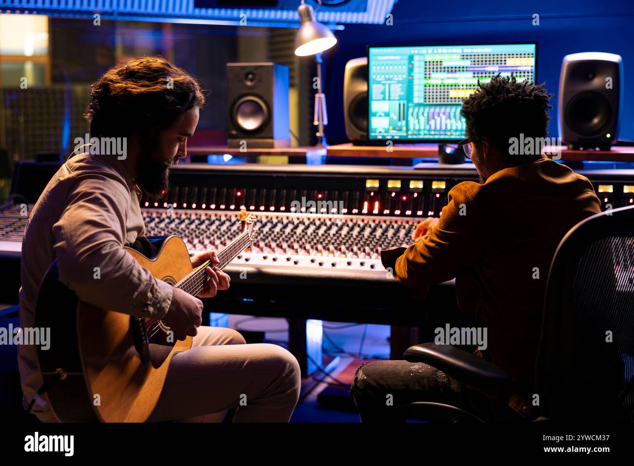 Musician records electro acoustic guitar sounds with technician in ...