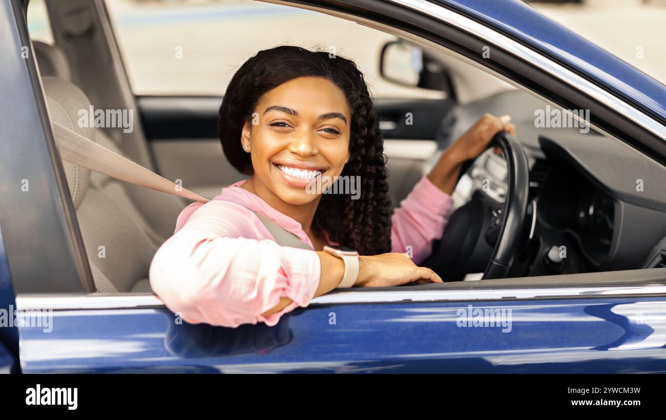 Smiling black woman driving new car in the city Stock Photo - Alamy