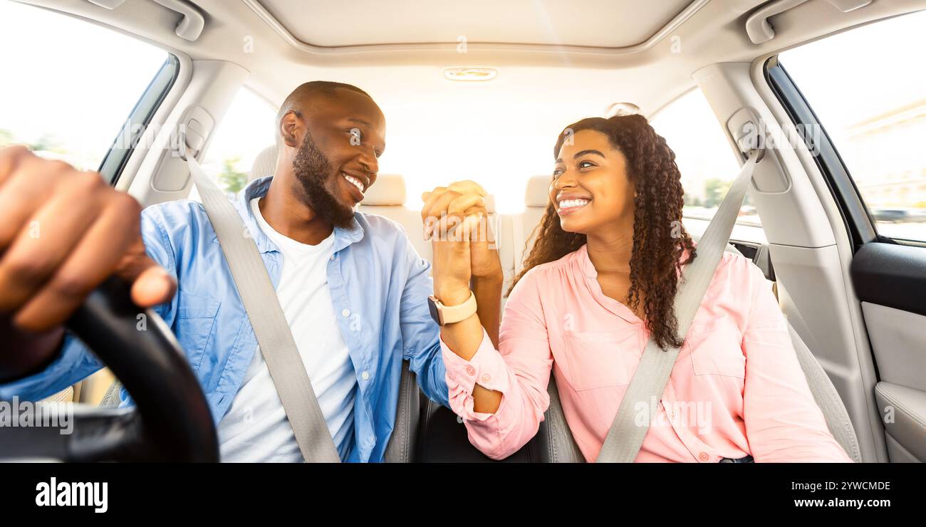 Happy black couple enjoying drive on car, holding hands Stock Photo - Alamy