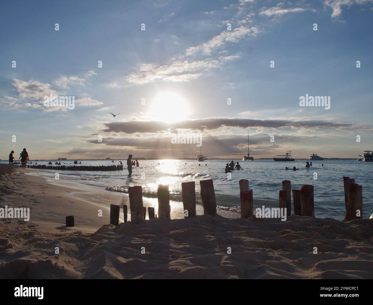 People swimming in the ocean during early sunset at Playa Norte, Isla ...