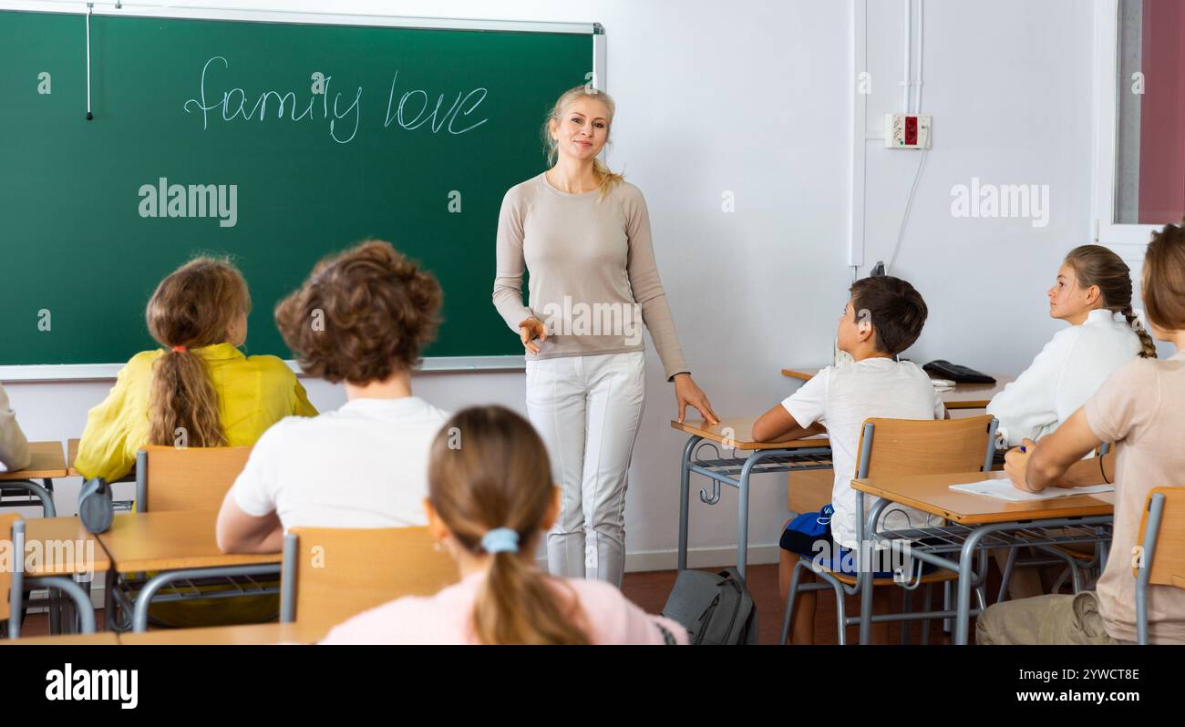 Female teacher giving lesson to children in school Stock Photo - Alamy