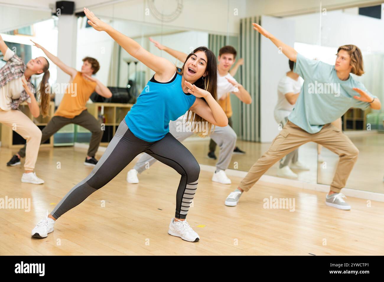 Cheerful emotional teen girl training dance movements in choreography ...