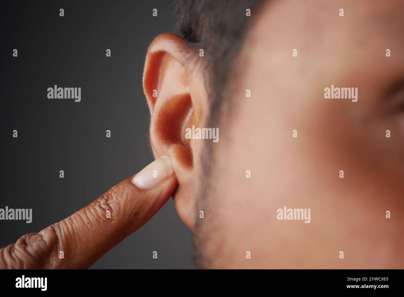 young man having ear pain touching his painful ear Stock Photo - Alamy
