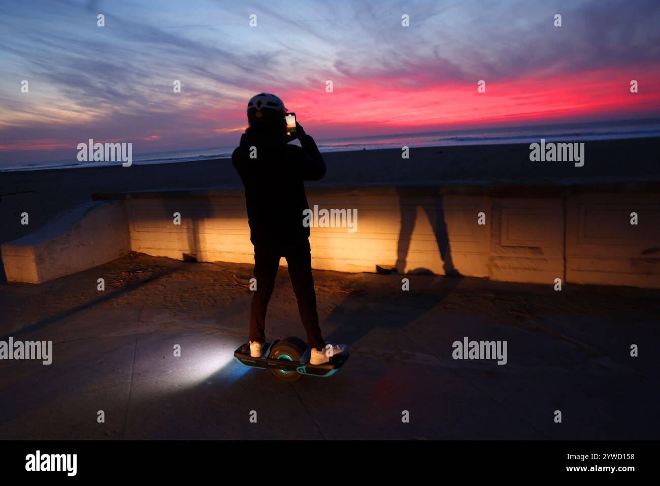 Eddie Shimmon rides on his Onewheel as he photographs the sunset at ...