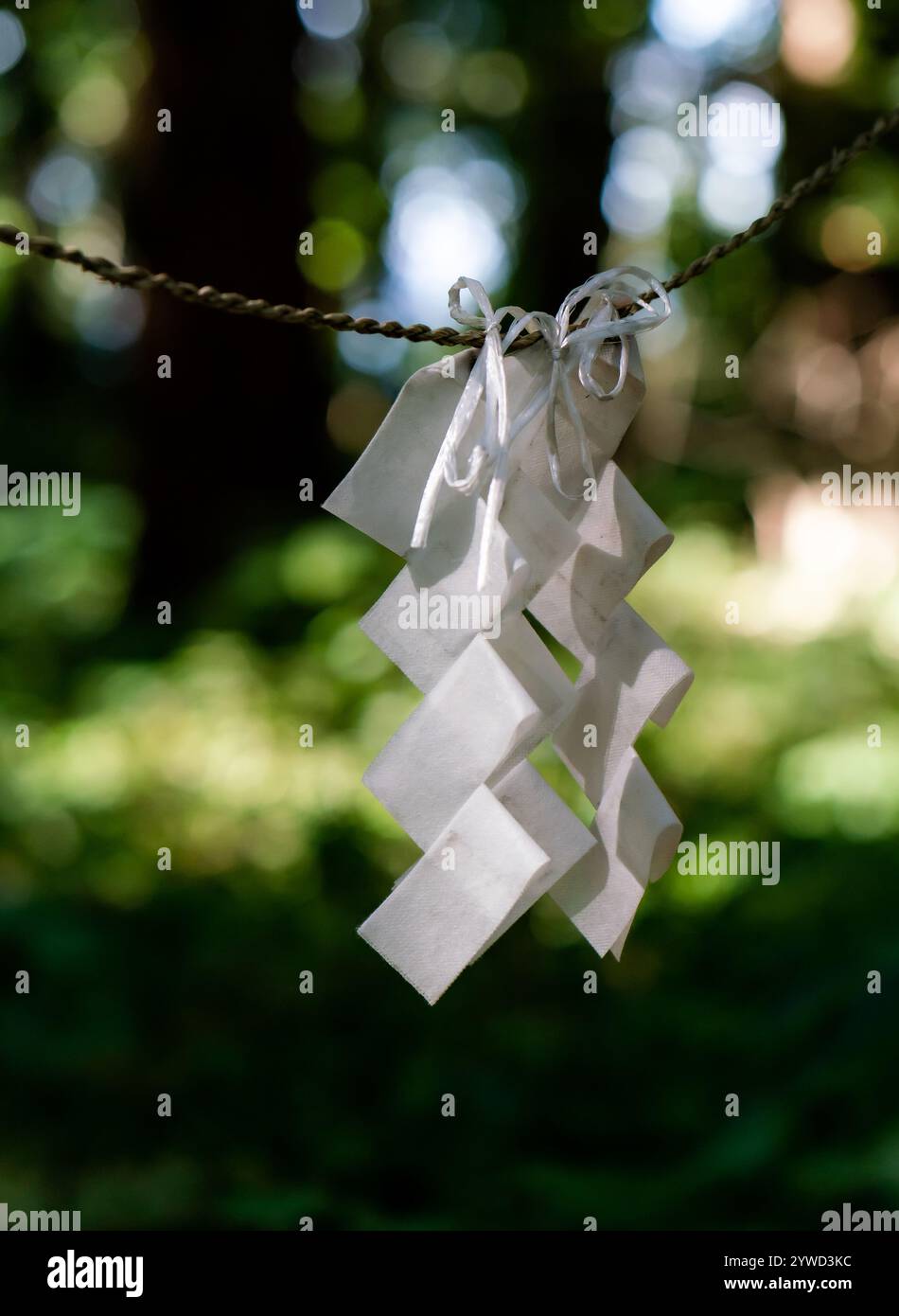 A zigzag-shaped paper streamer used in Shinto rituals to mark sacred ...