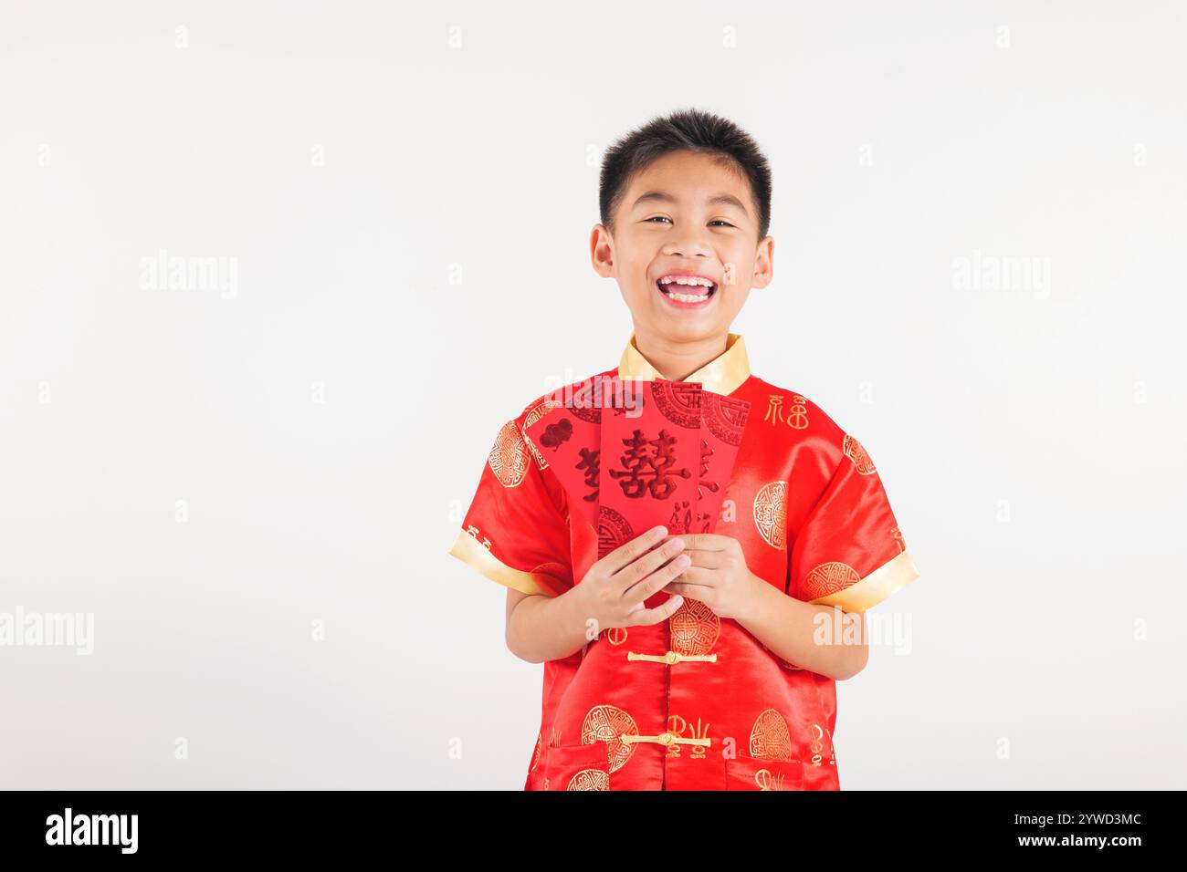 Cheerful Asian boy wearing a red cheongsam qipao dress holds an angpao ...
