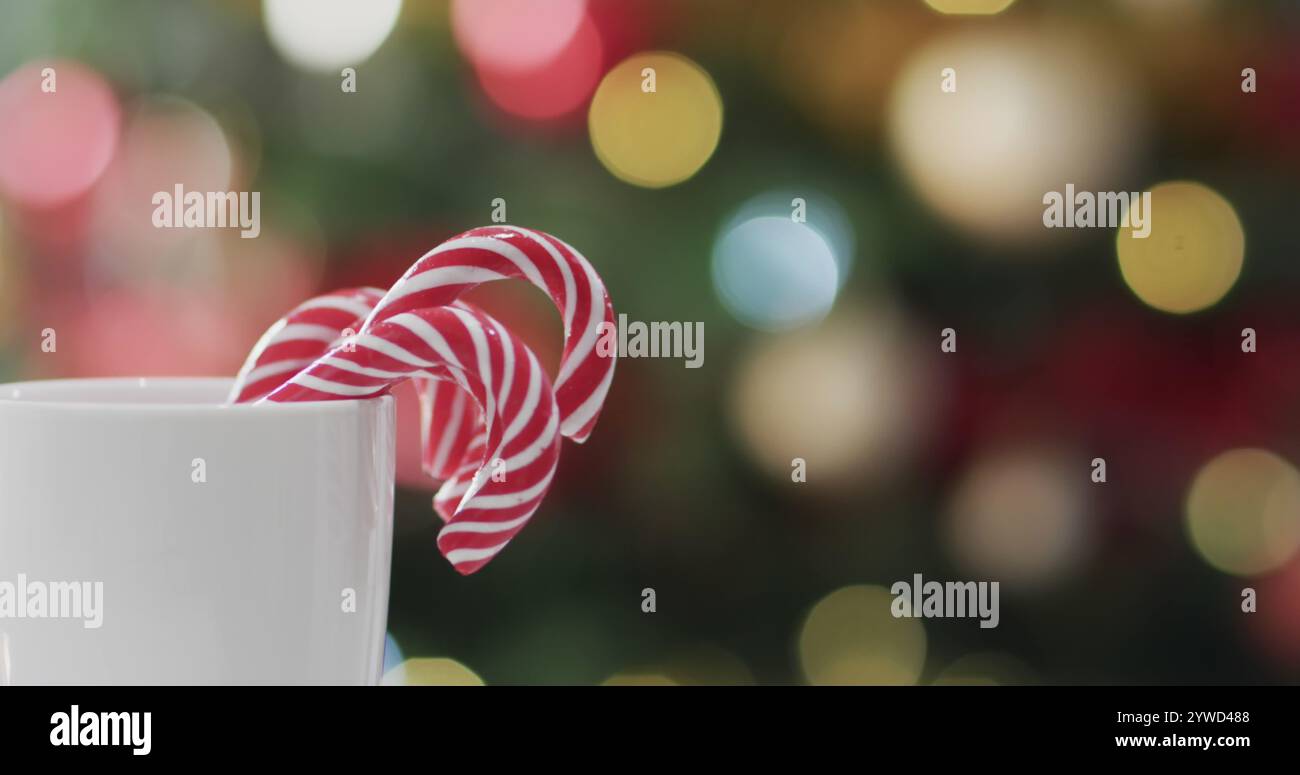 Candy canes rest in a mug against a festive backdrop, with copy space ...