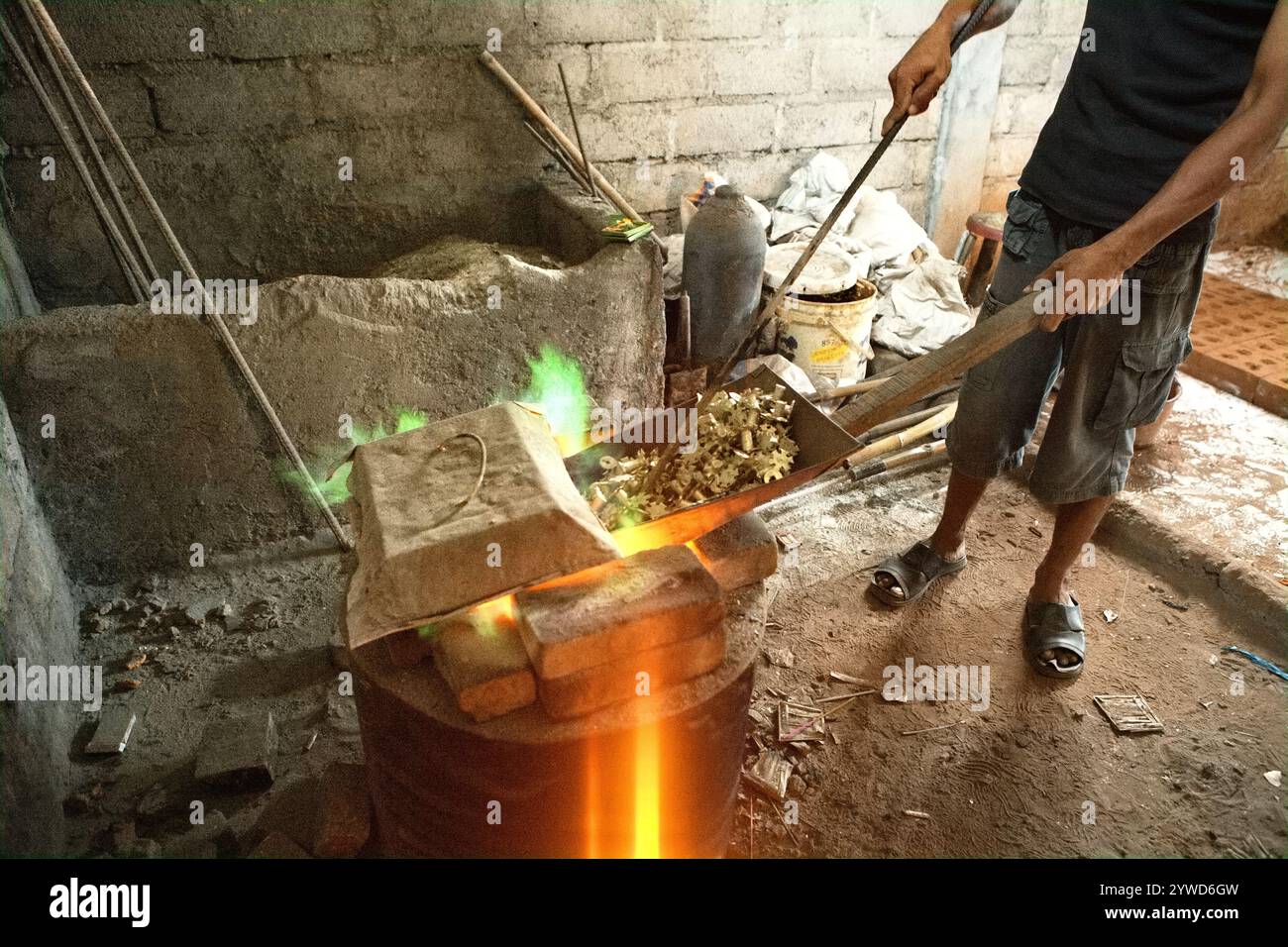 A worker melting metal as a part of production process in the making of ...