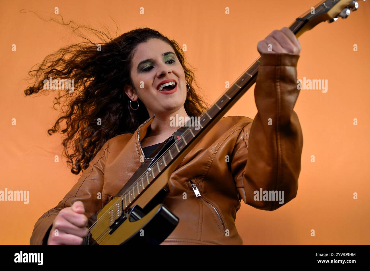 Musician expressing herself through music, playing electric guitar with ...