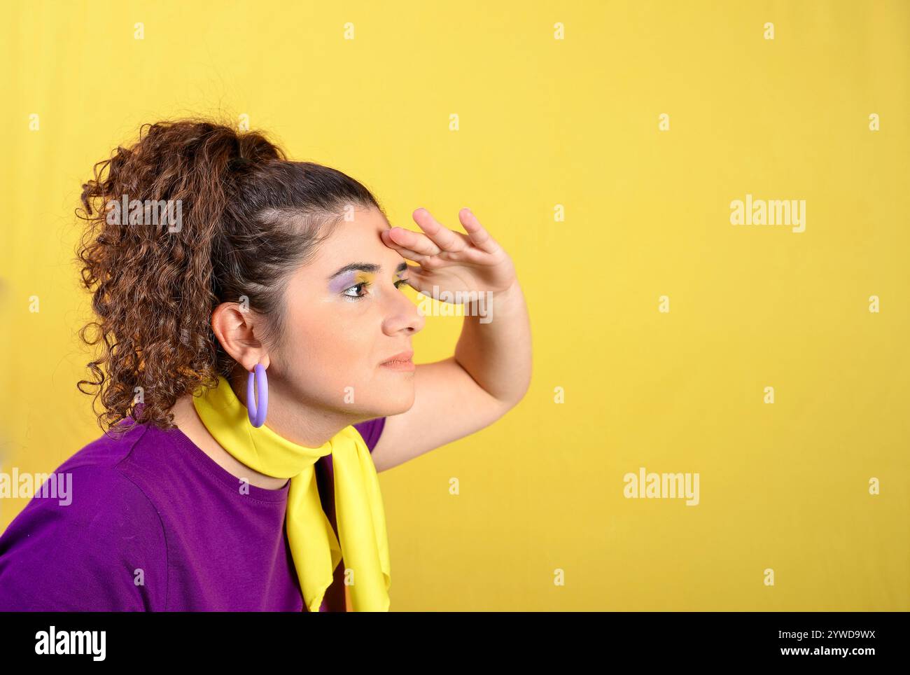 Curious hispanic woman shielding her eyes from the sun while looking ...