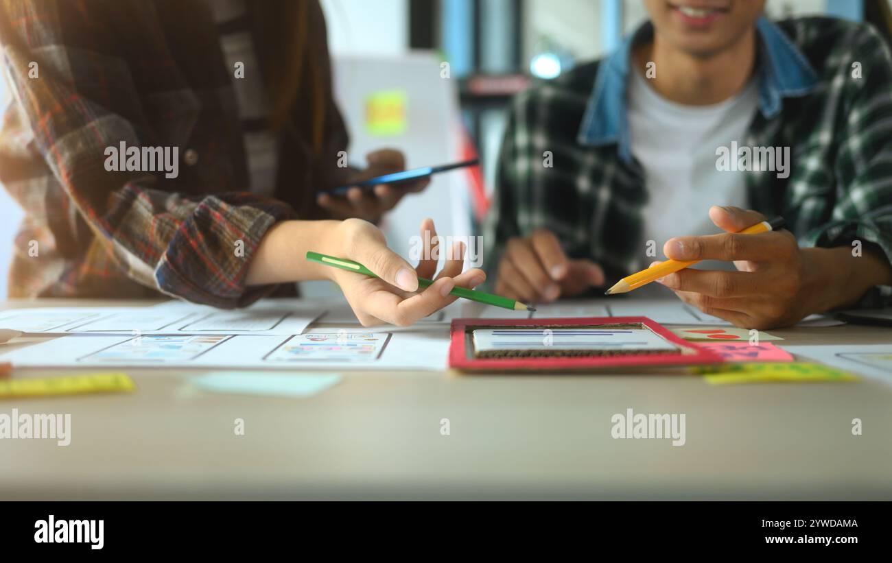 Creative team discussing ideas over design sketches and prototypes on a ...