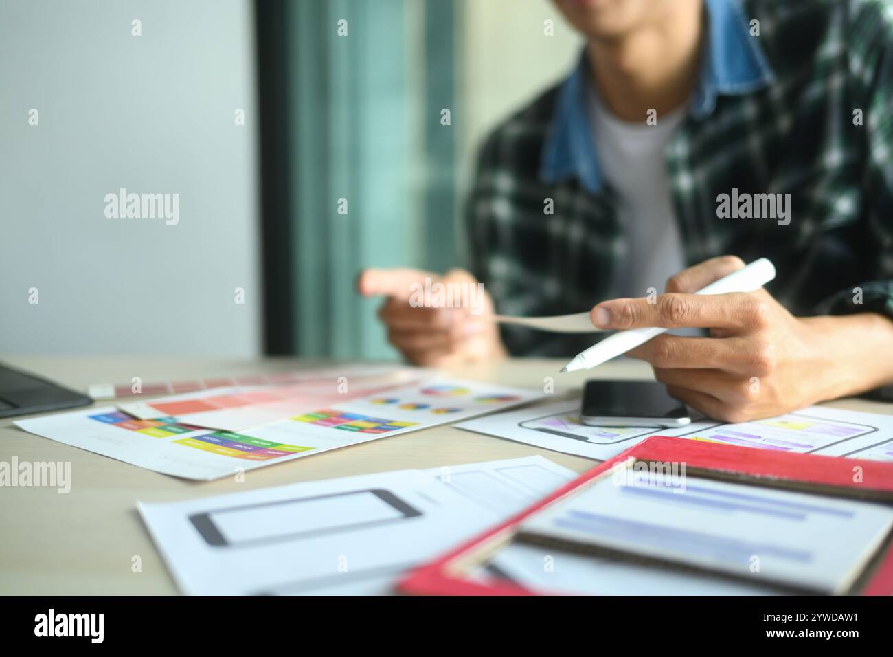 Designer analyzing color swatches and wireframe sketches while working ...