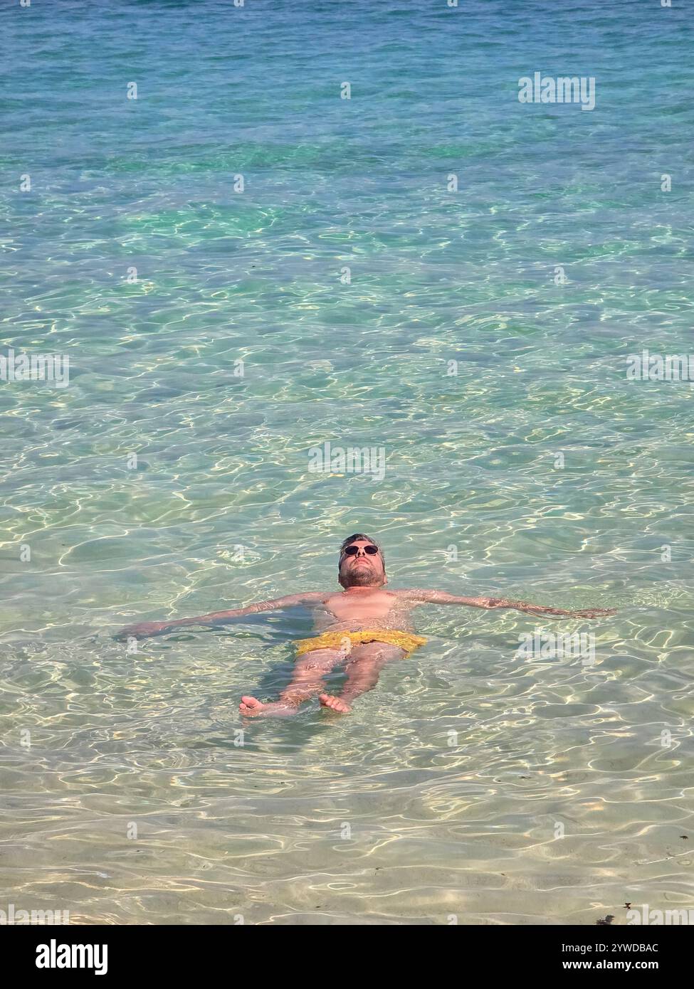 A serene moment unfolds as a sunbather floats effortlessly in the ...