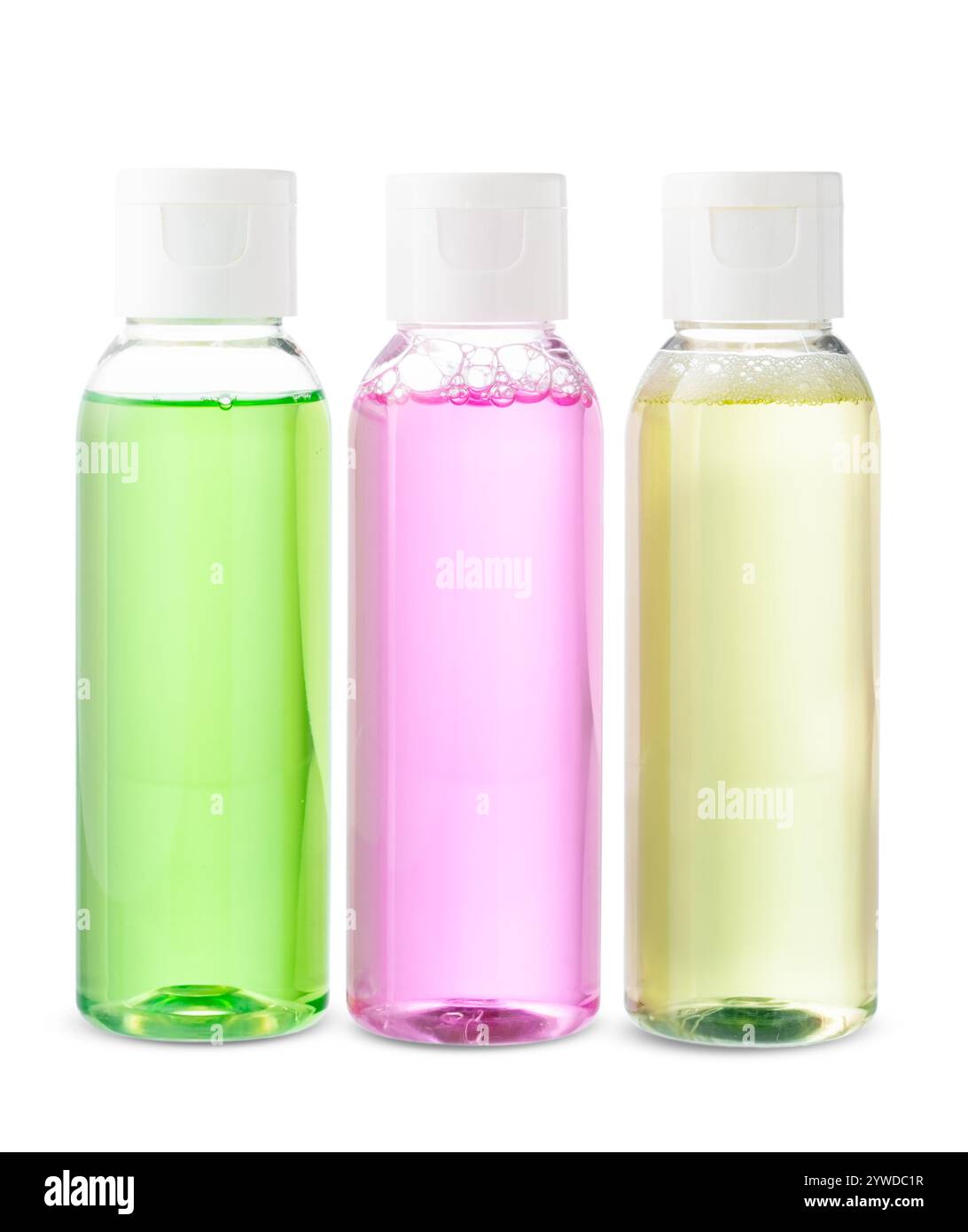 Various bottles with colored liquids and pumps arranged on white ...