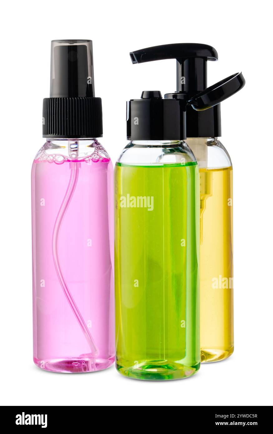 Various bottles with colored liquids and pumps arranged on white ...