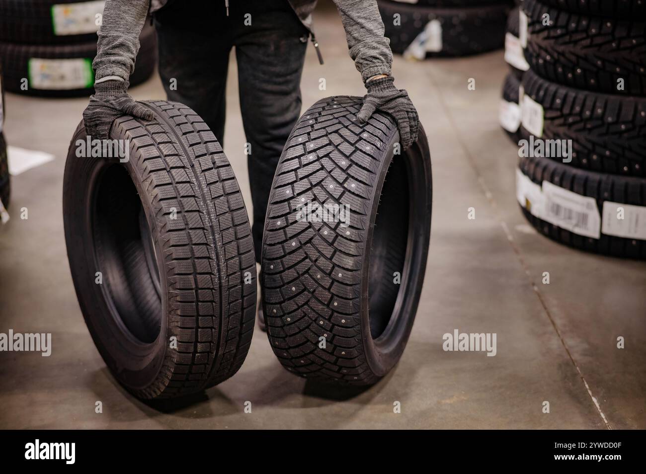 Mechanic keeps new summer and winter car tires in the garage. Comparison of wheels for different ...