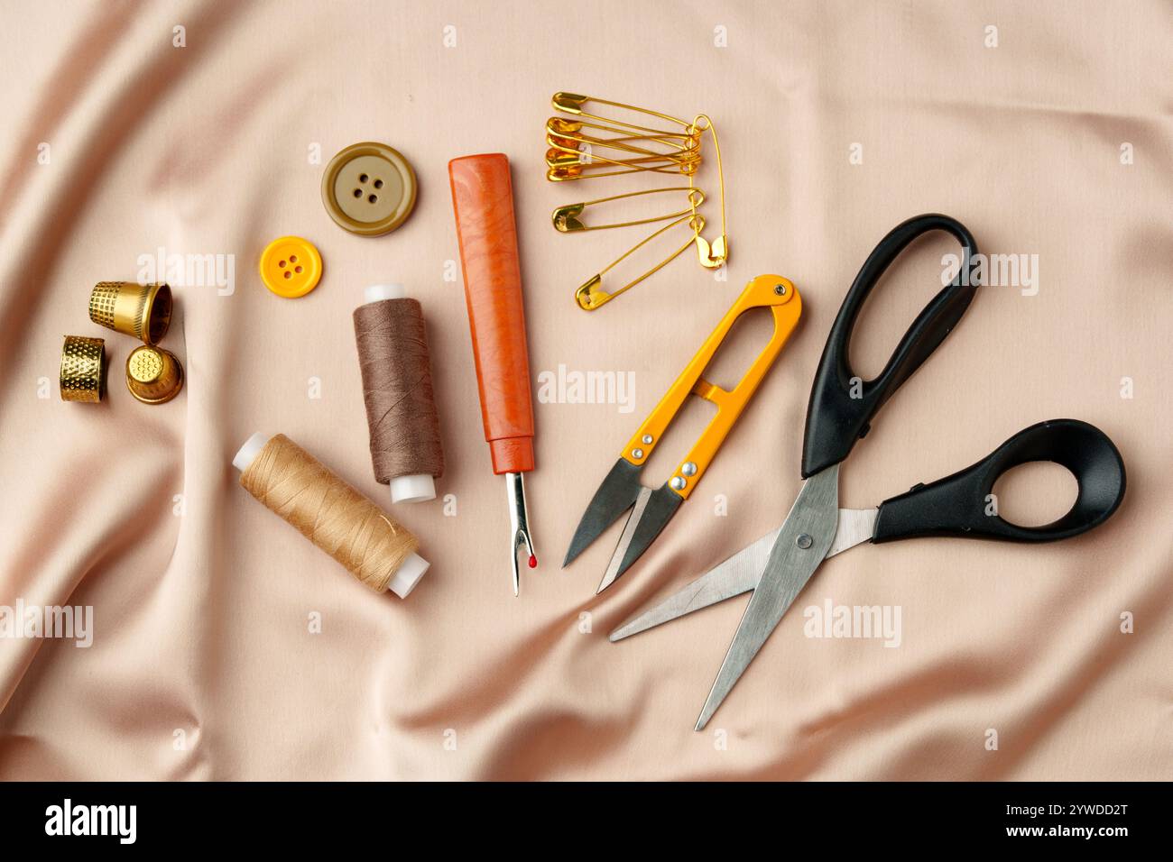 Sewing tools and materials arranged on soft fabric showcasing essential ...