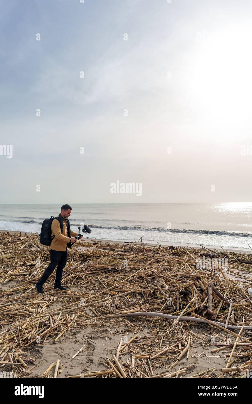 Videographer is documenting the aftermath of a flood on a beach ...
