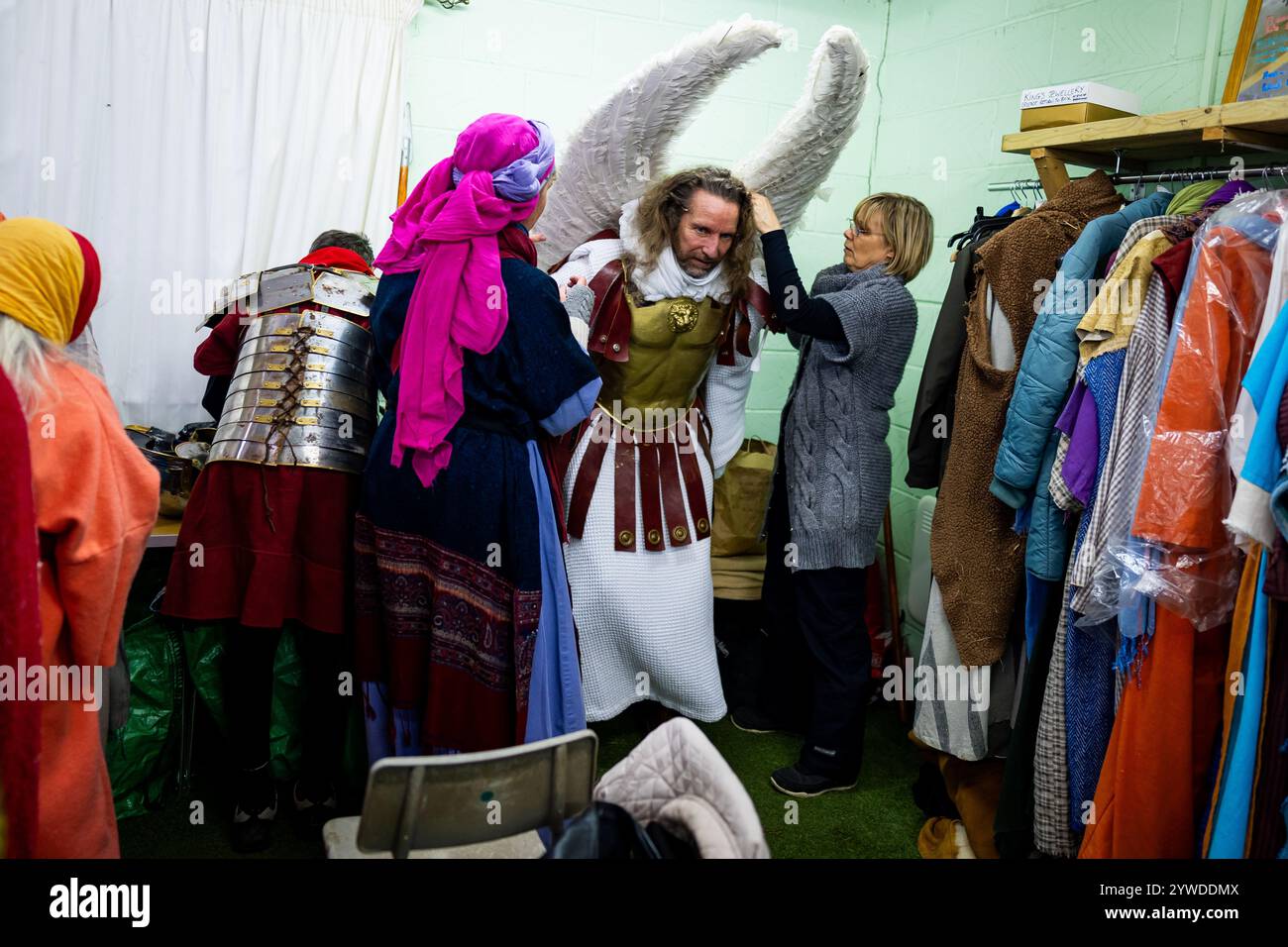 An actor playing Archangel Gabriel is helped into costume at the dress ...