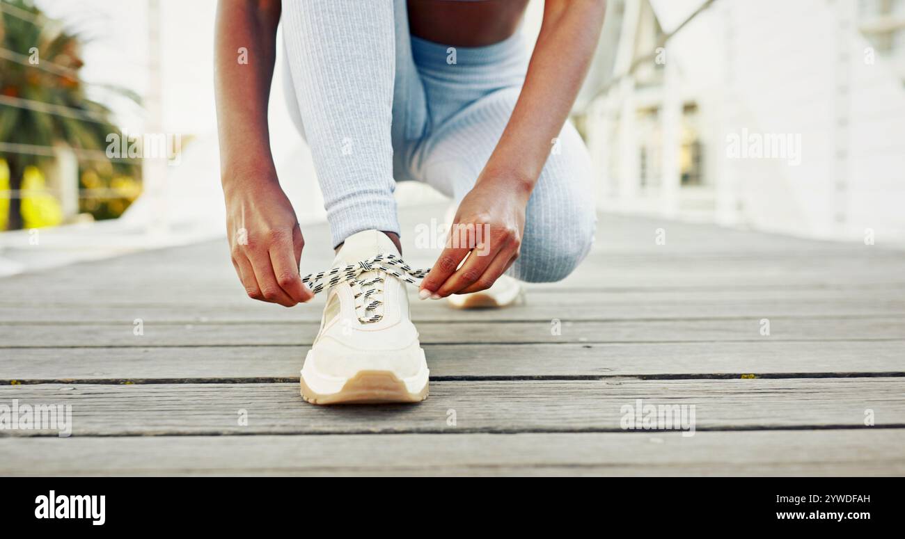 Woman, tying shoes and city athlete for getting ready, running training ...