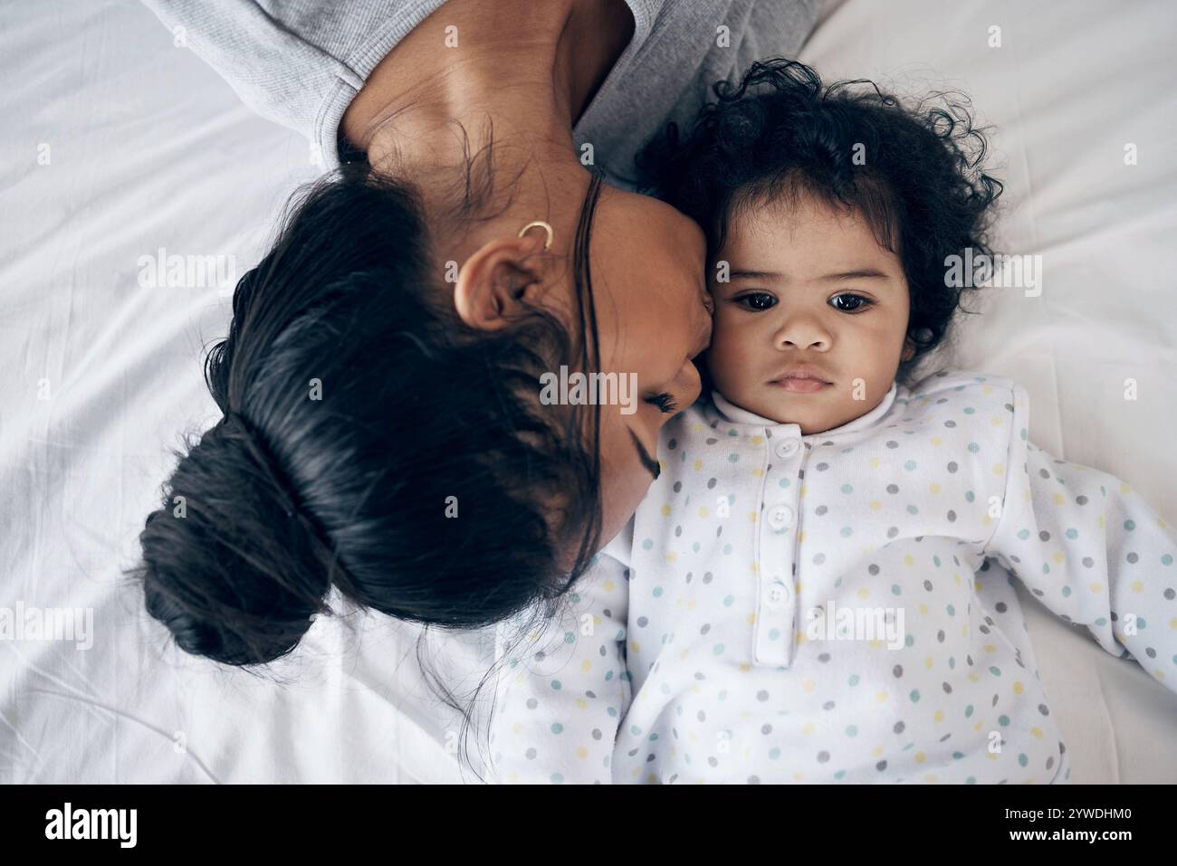 Bonding, mother and kiss baby on bed for affection, child development ...