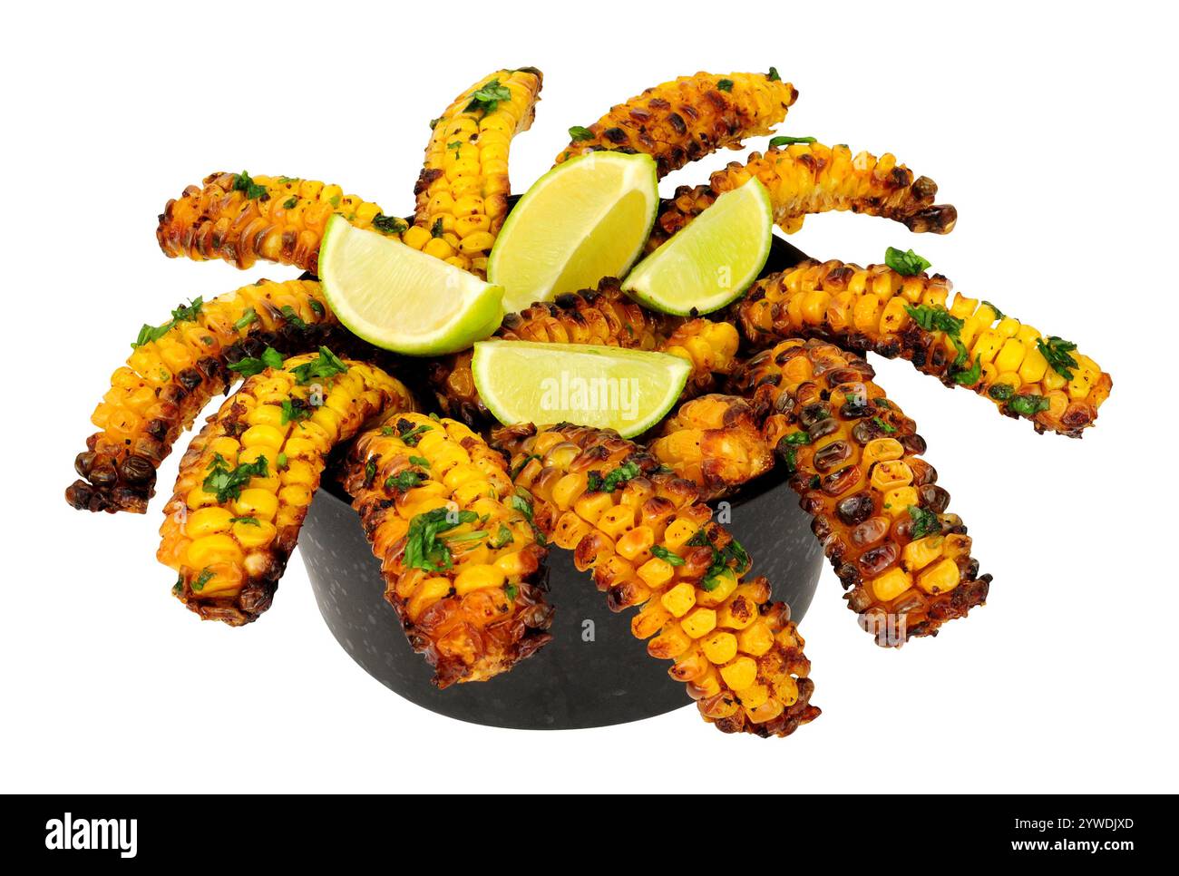 Portion of baked sweet corn ribs with herb garnish and lime wedges on a ...