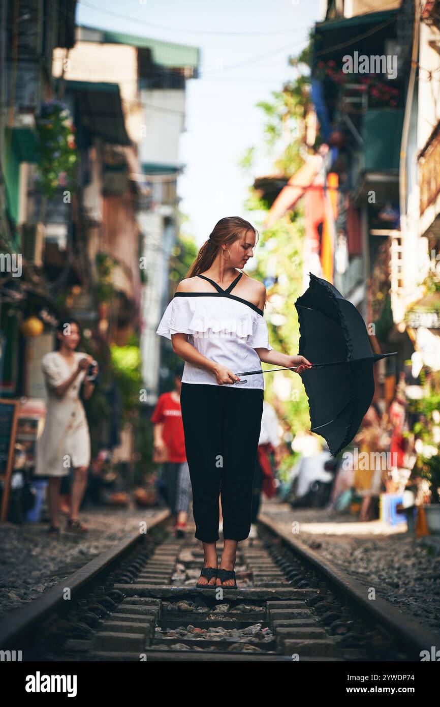 Happy woman, umbrella and railway in city for sightseeing, explore and ...
